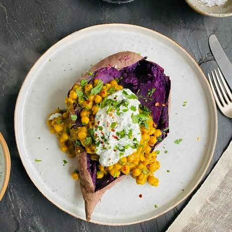 Baked purple sweet potatoes with turmeric chickpeas & herb... / Riverford